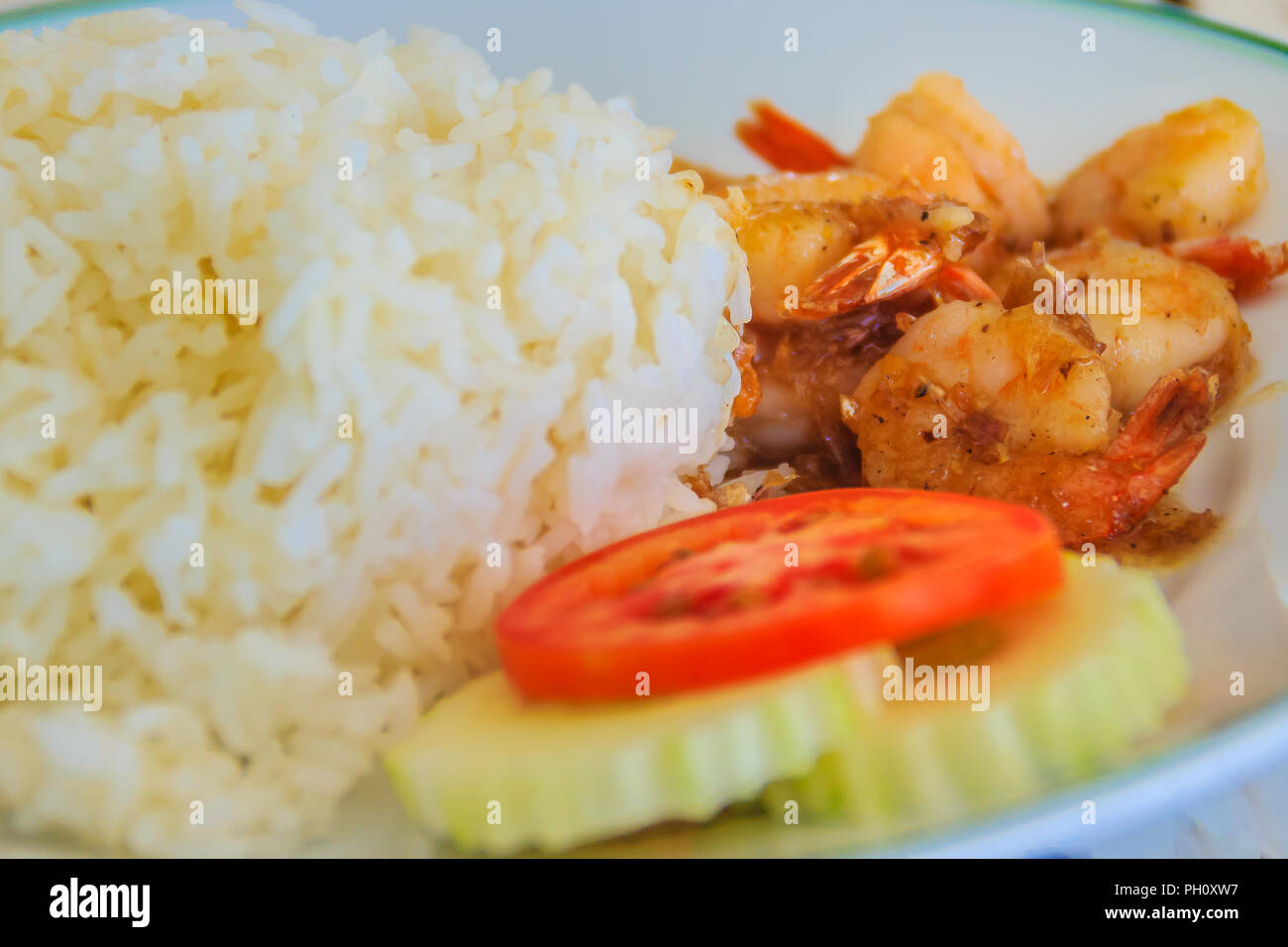 Close up fried shrimp with garlic on rice dish decorated with sliced ...