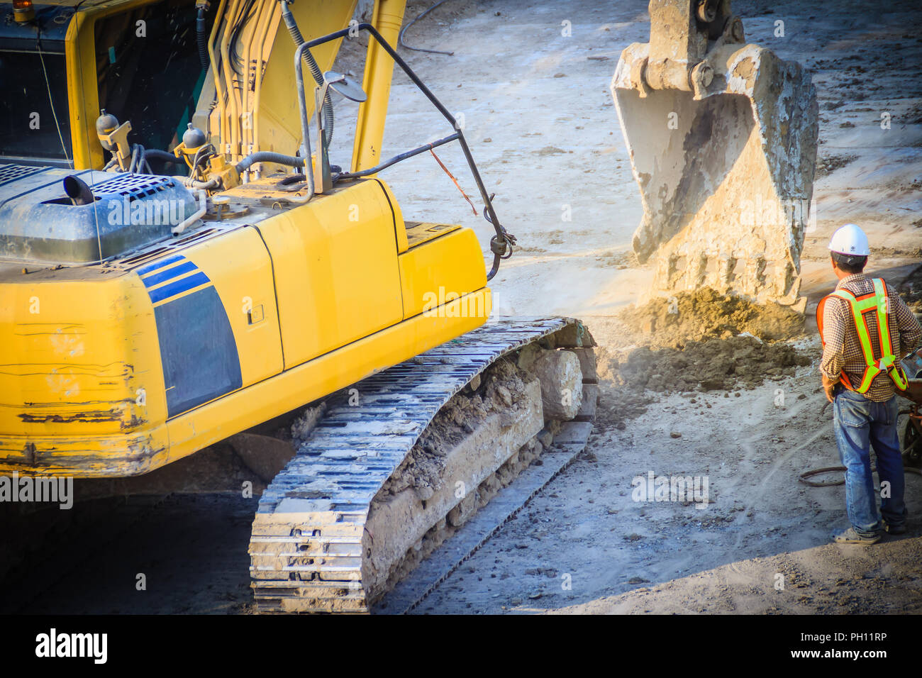 Civil engineer foreman is supervising backhoe to digging for earthwork ...