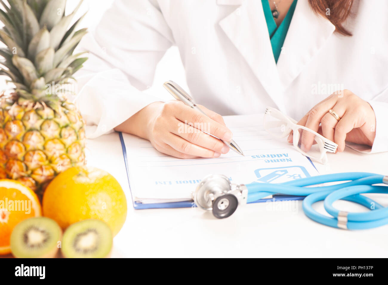 Nutritionist writing medical records and prescriptions with fresh ...