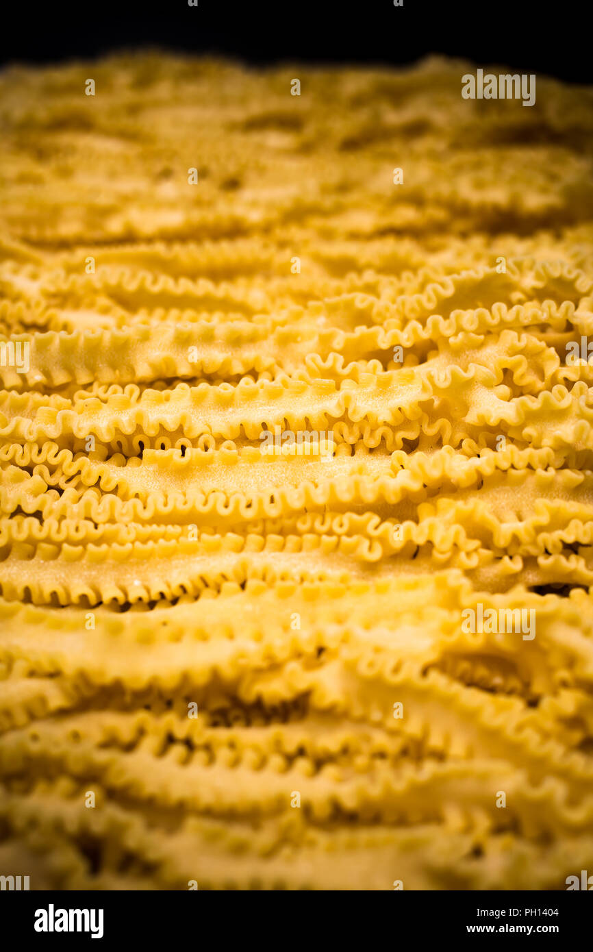 Rows of mafalde pasta with black background Stock Photo - Alamy