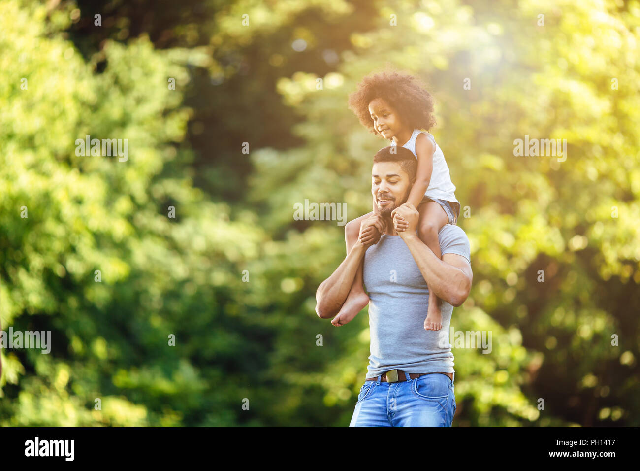 Portrait of young father carrying his daughter on his back Stock Photo ...
