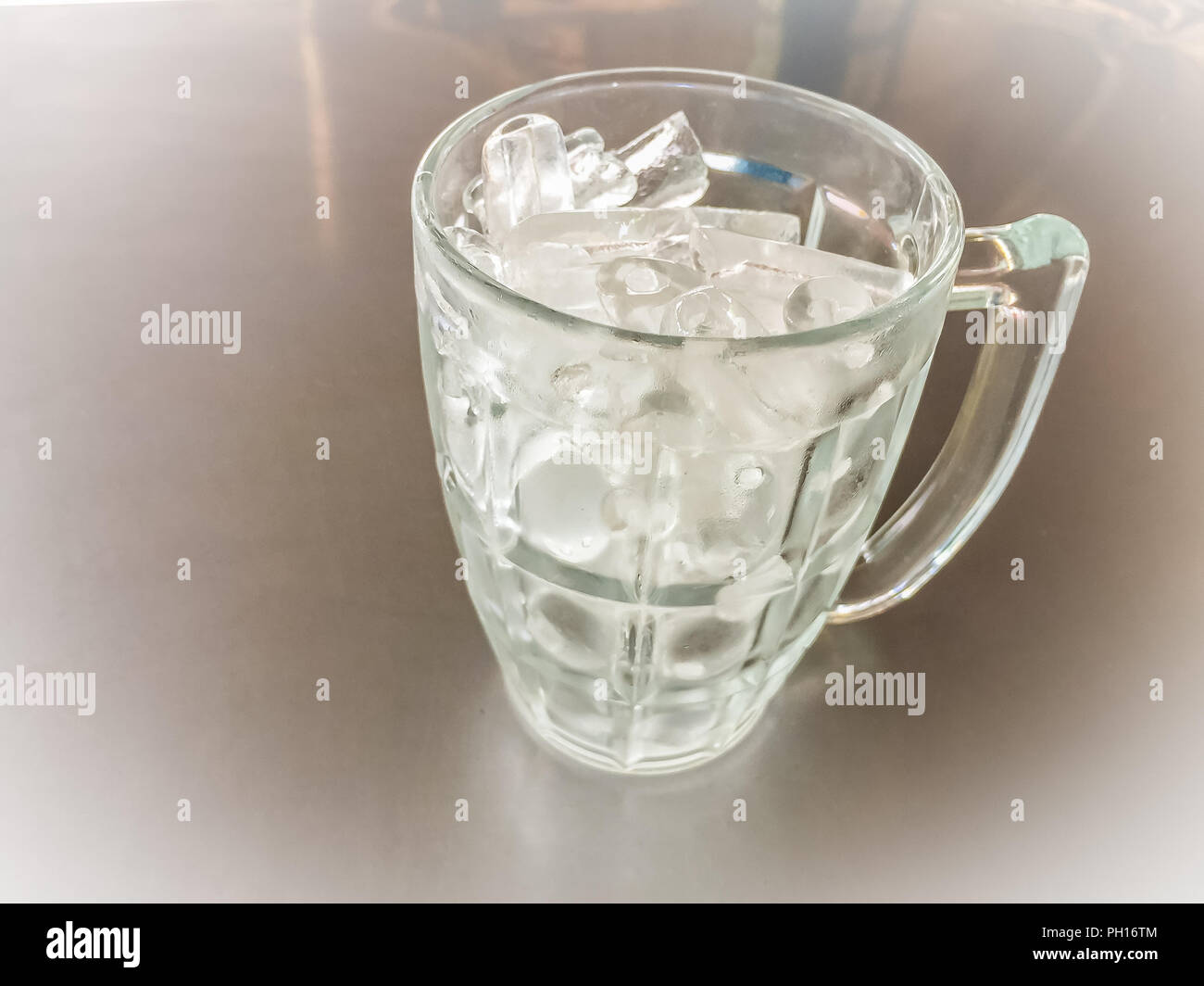 Small cylinder shaped of ice in the glass jug put on the steel table ...