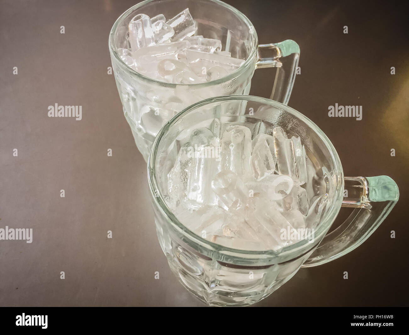Small cylinder shaped of ice in the glass jug put on the steel table ...