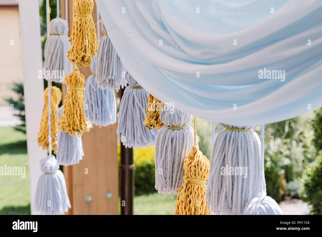 Handmade elegant wedding decor. Tassels made of thread on a festive ...