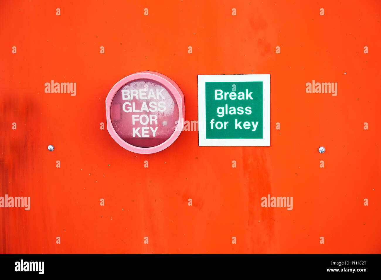 Break glass for key sign and container fixed to orange background wall ...