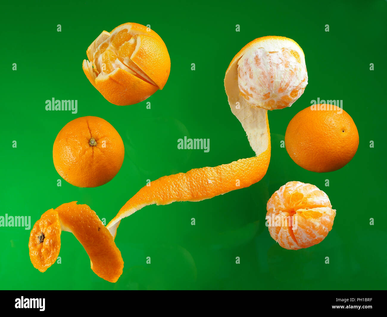 Oranges in different state of peeling suspended in the air Stock Photo ...