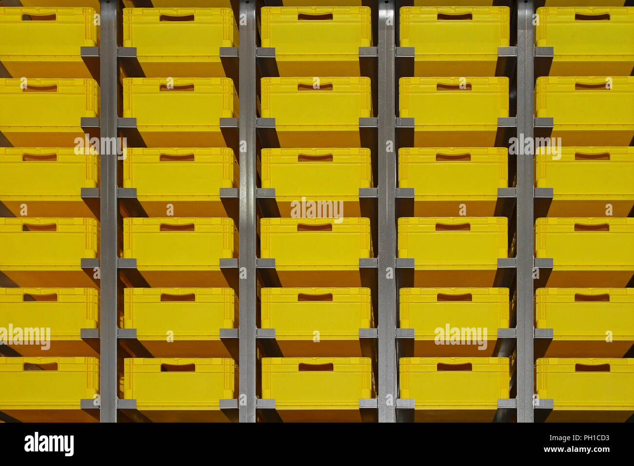 Yellow plastic crates at shelves in warehouse Stock Photo - Alamy