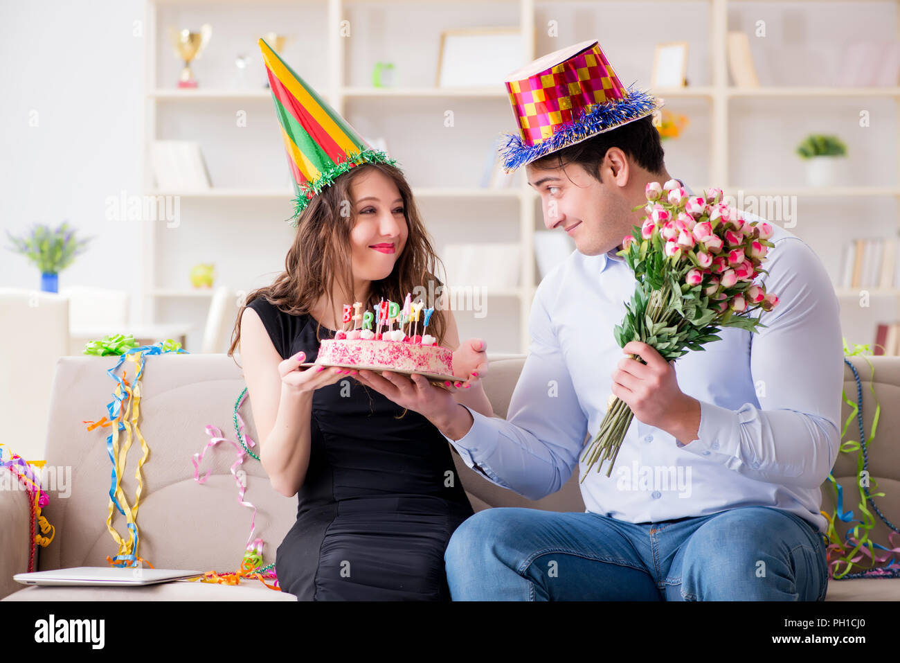 Young couple celebrating birthday with cake Stock Photo - Alamy