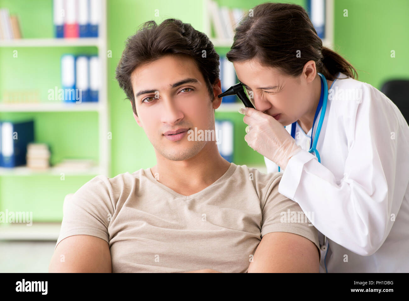 Female doctor checking patient's ear during medical examination Stock ...