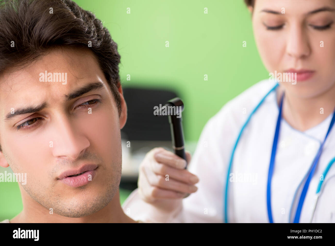 Female doctor checking patient's ear during medical examination Stock ...