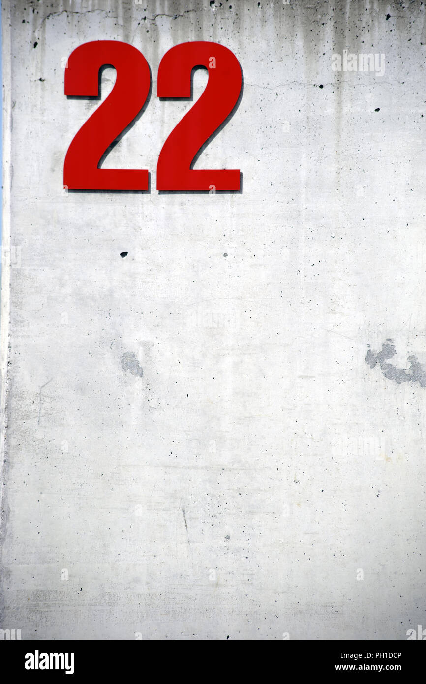 A building number, number twenty-two on a striking concrete wall Stock ...