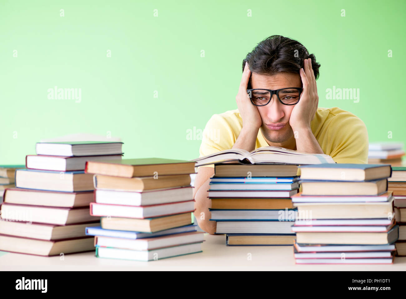 Student with too many books to read before exam Stock Photo - Alamy