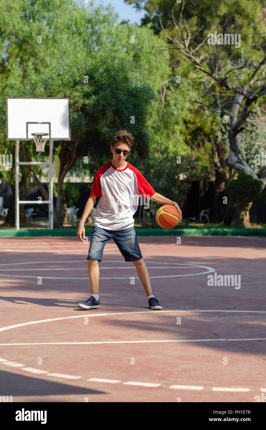 The boy is playing basketball alone in the basketball court Stock Photo ...
