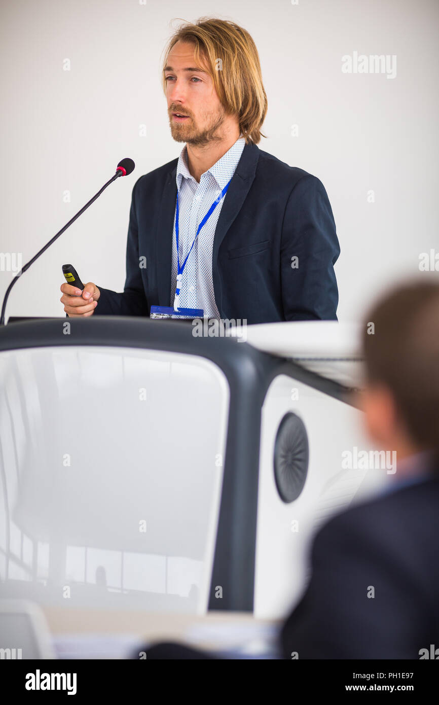 Handsome young man giving a speech at a conference Stock Photo - Alamy