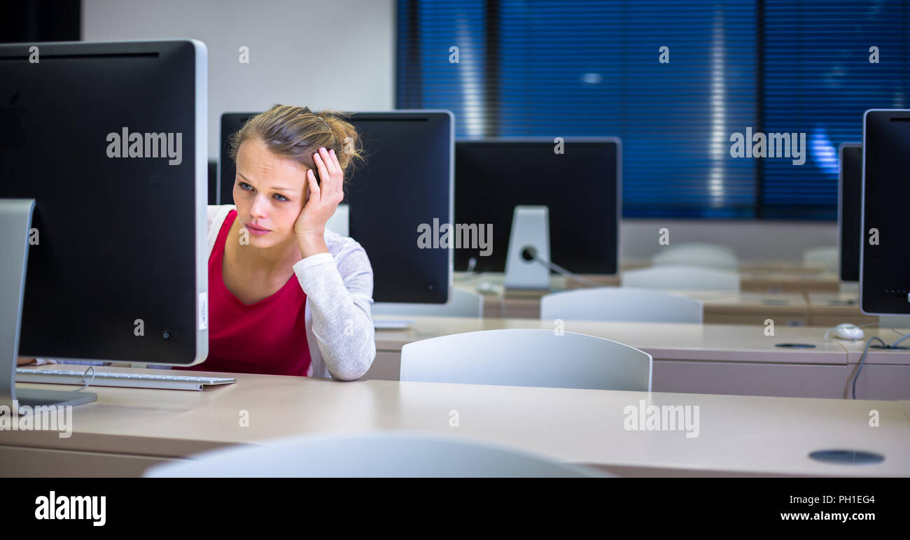 Pretty, young female college student using a desktop computer/pc in a ...