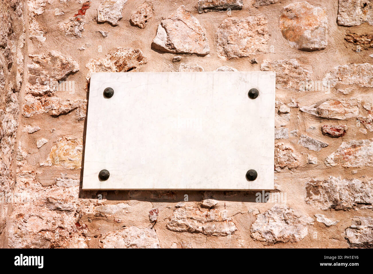 White marble sign. White marble sign on a stone wall Stock Photo - Alamy