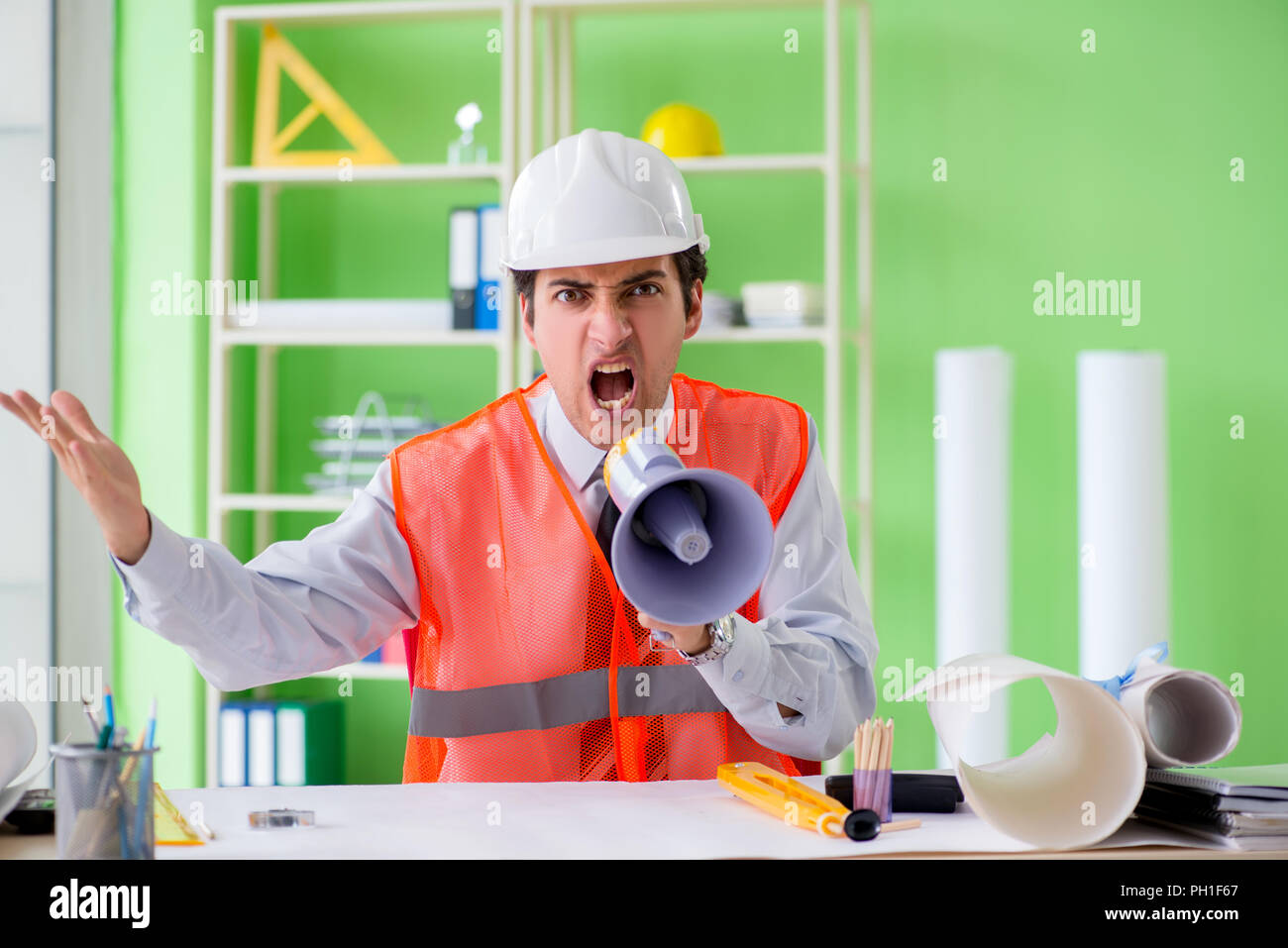 Construction supervisor with loudspeaker sitting in the office Stock ...