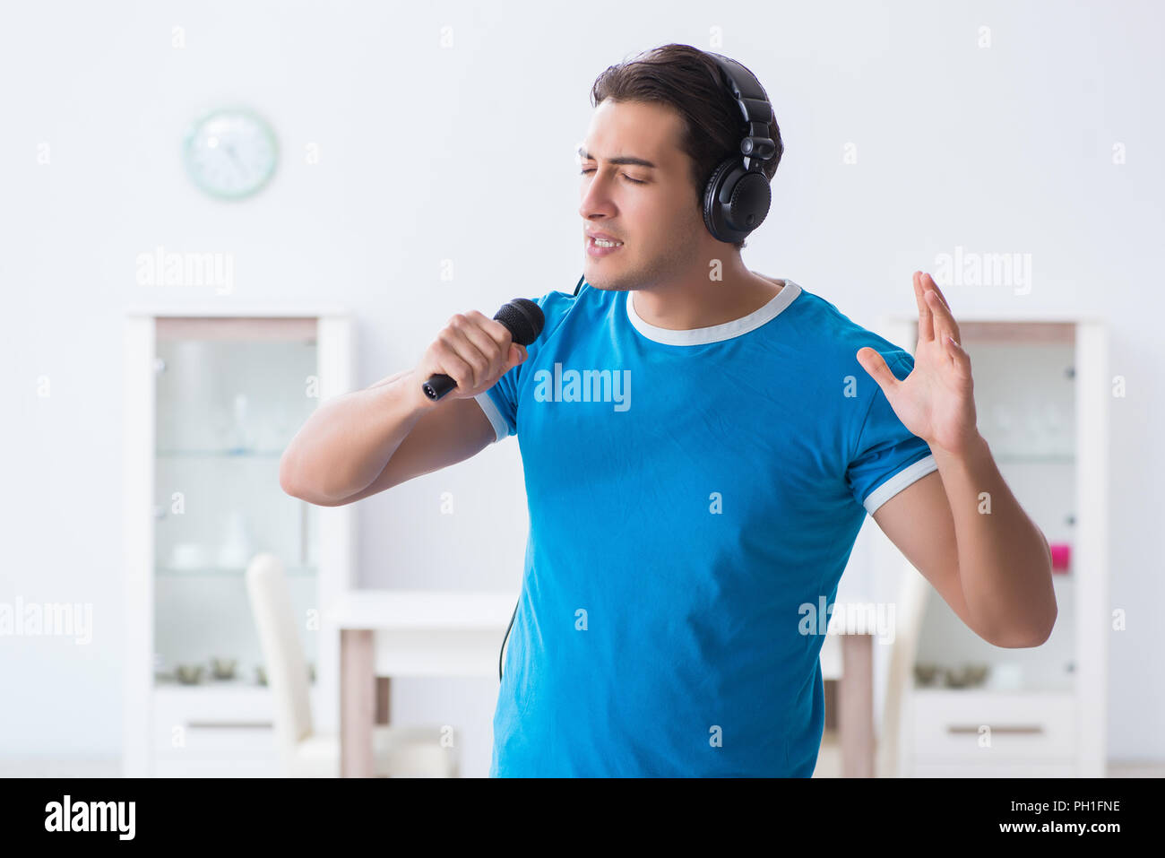 Young handsome man singing karaoke at home Stock Photo - Alamy