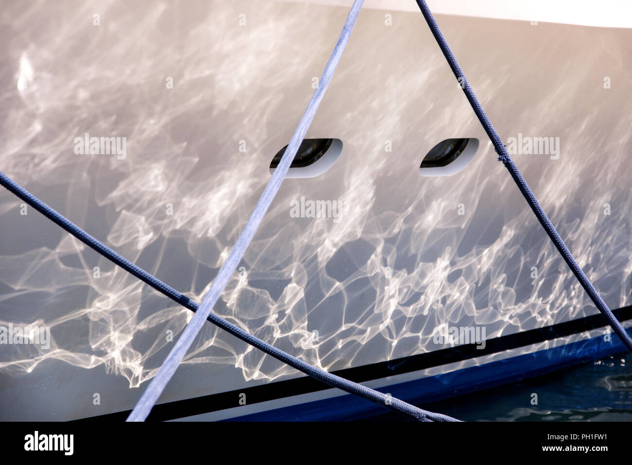 Part of white yacht with blue ropes anchored in the harbor. The texture ...