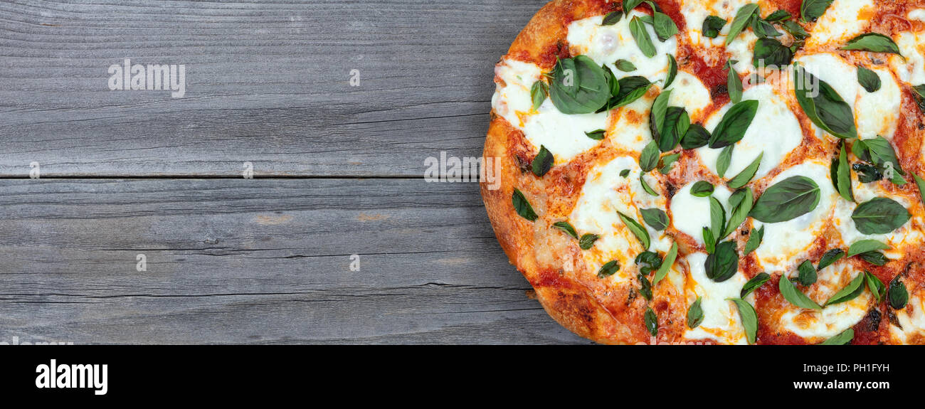 Top view of tomato and cheese homemade cooked pizza on rustic wood ...