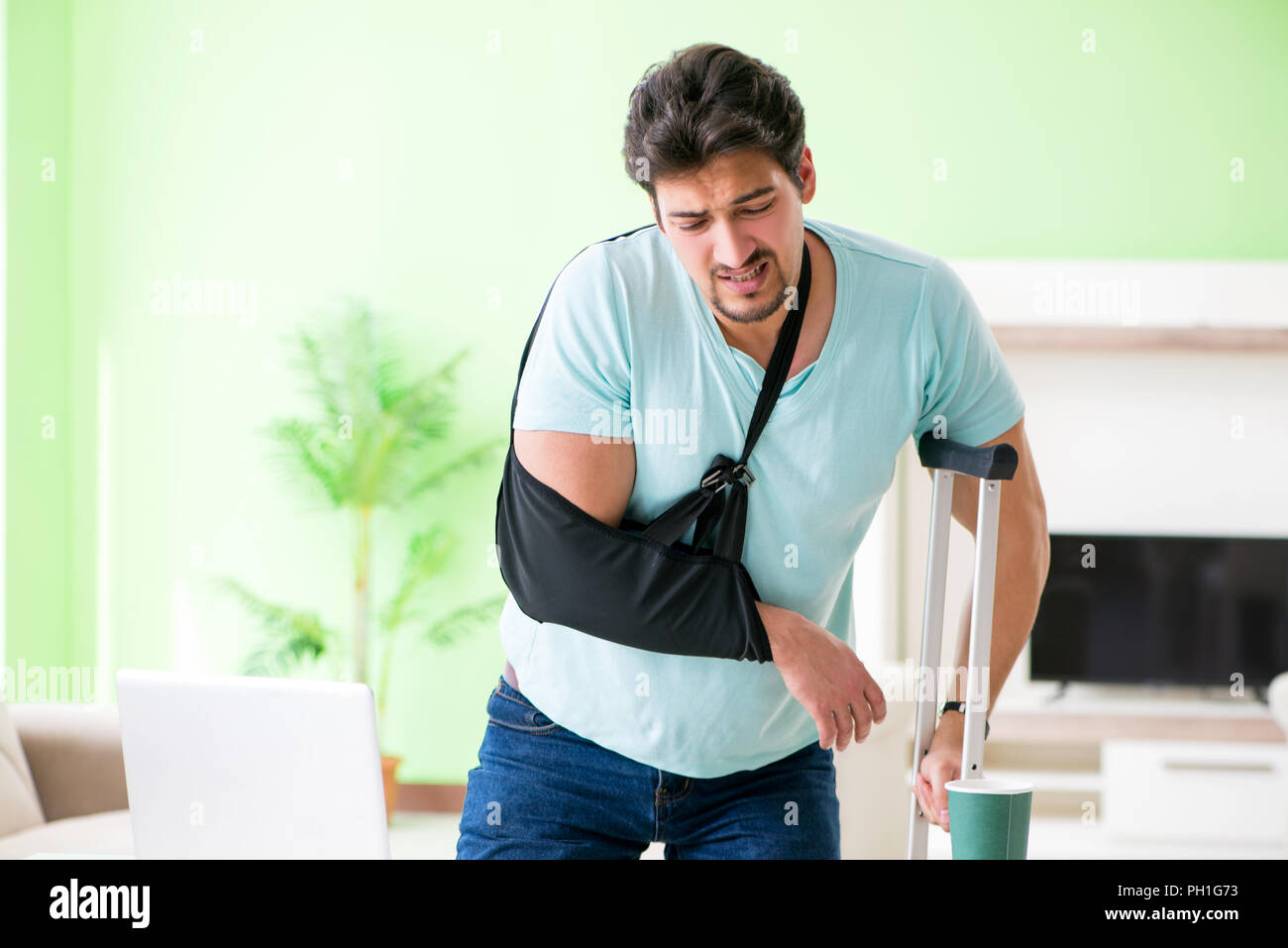 Injured man with crutches sitting at home Stock Photo - Alamy