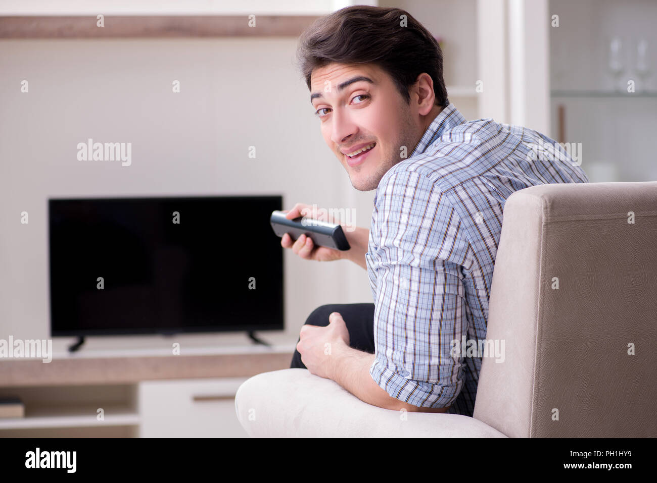 Young man watching tv at home Stock Photo - Alamy