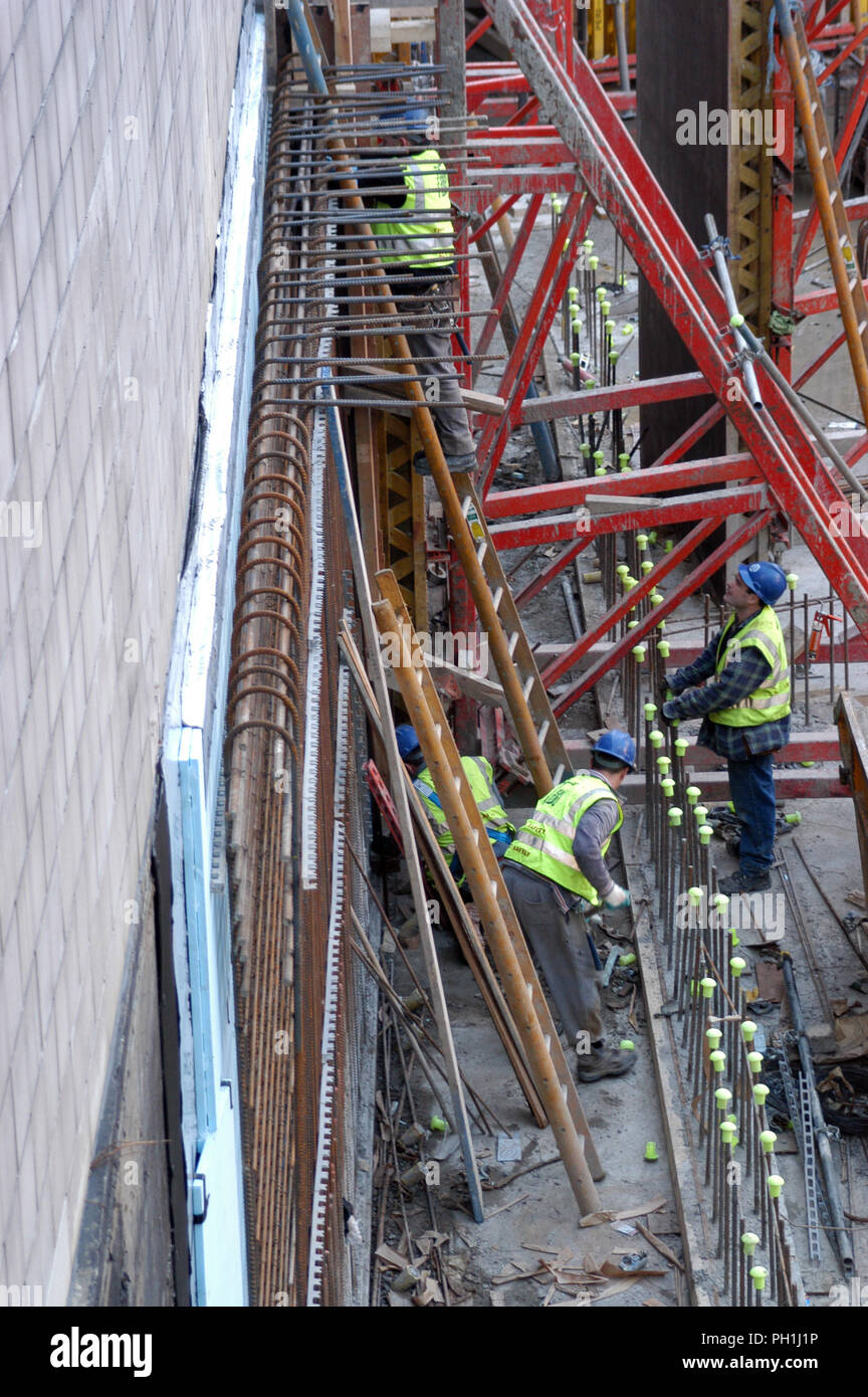 Builders fixing metal rods into wall before concrete pouring in the ...