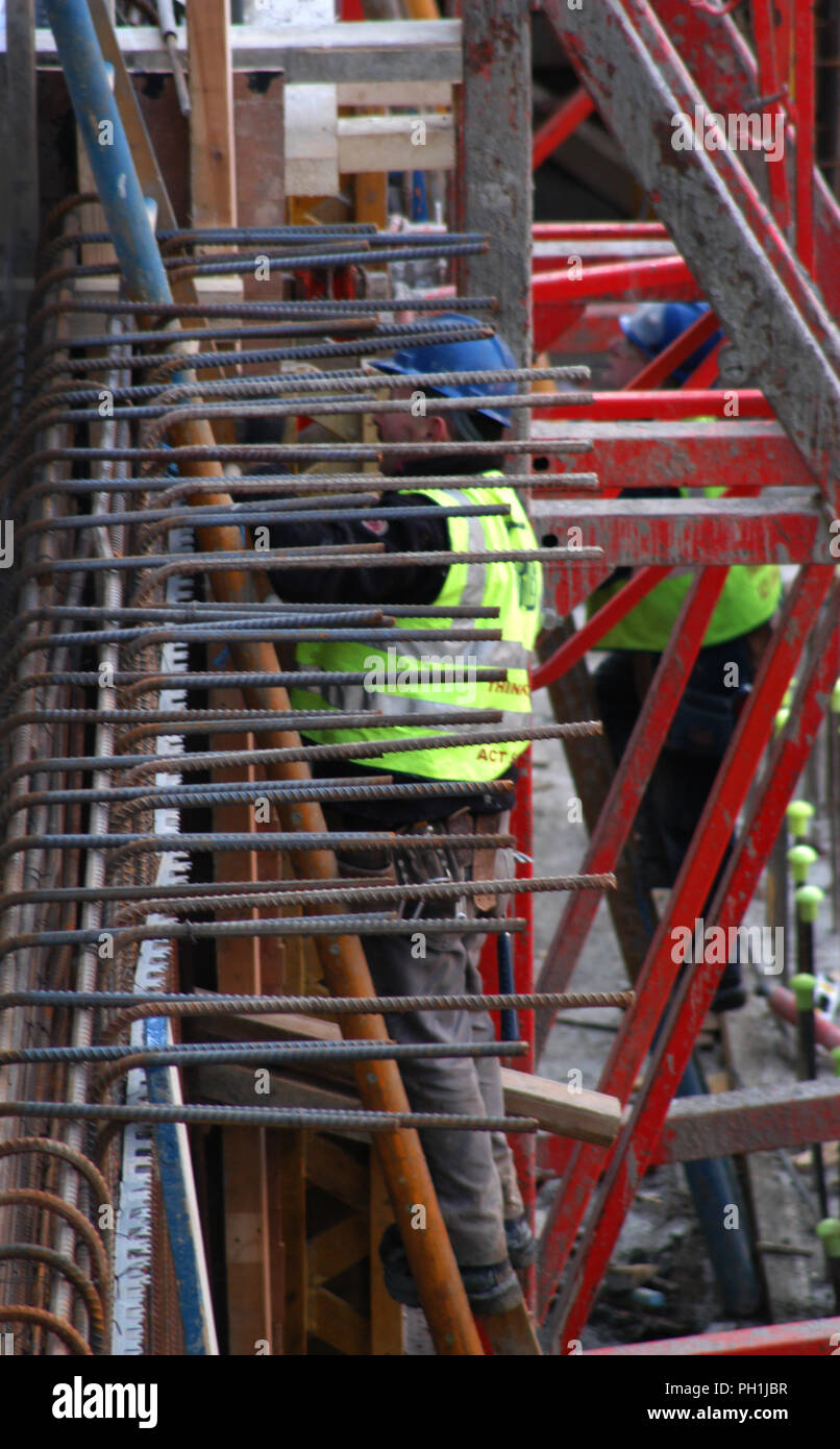 Builders fixing metal rods into wall before concrete pouring in the ...