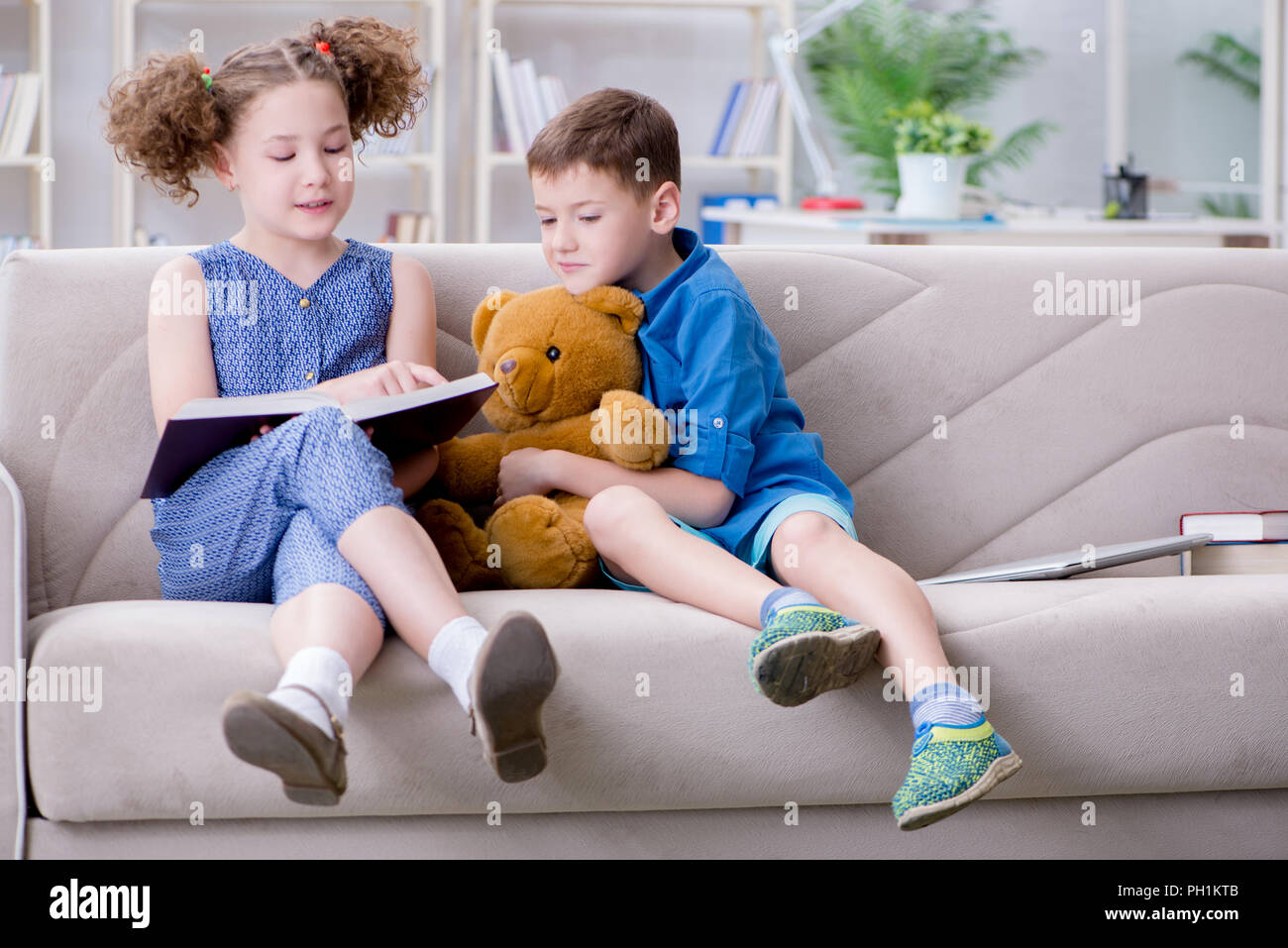 Two kids reading books at home Stock Photo - Alamy