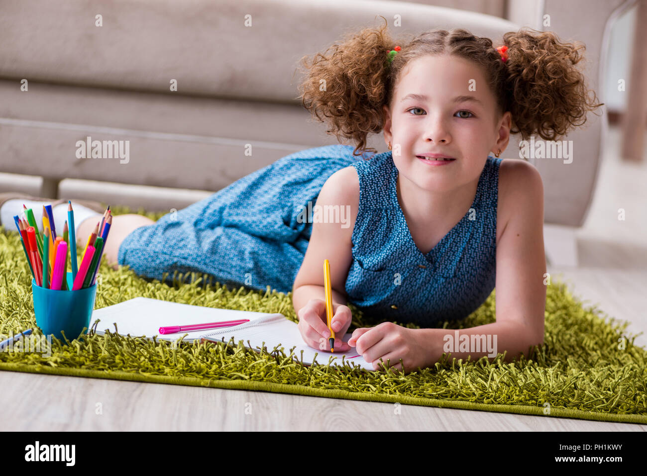 Young little girl drawing on paper with pencils Stock Photo - Alamy