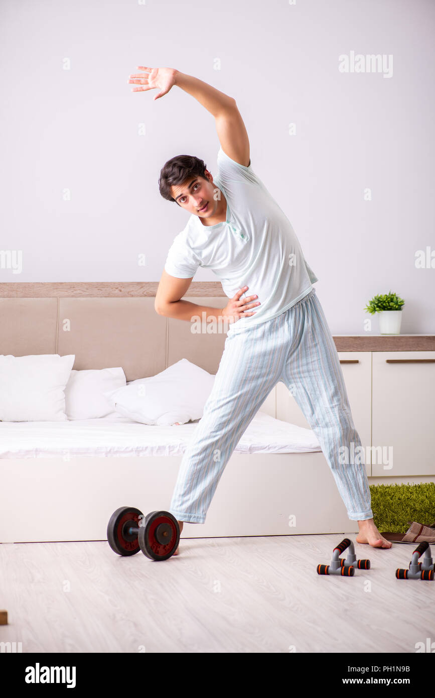 Young man doing morning routine in bedroom Stock Photo - Alamy