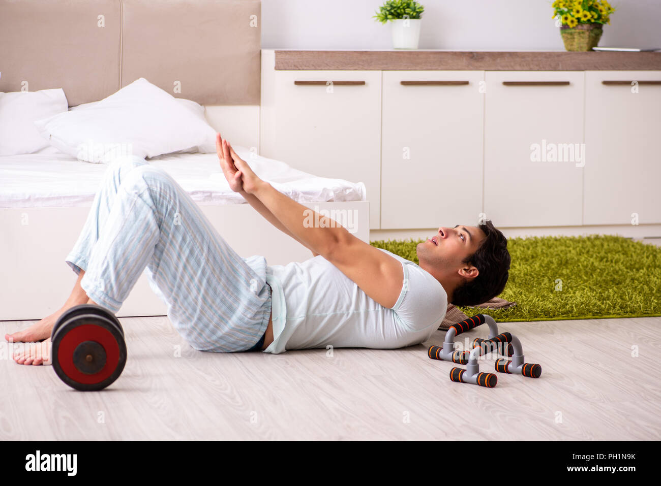 Young man doing morning routine in bedroom Stock Photo - Alamy