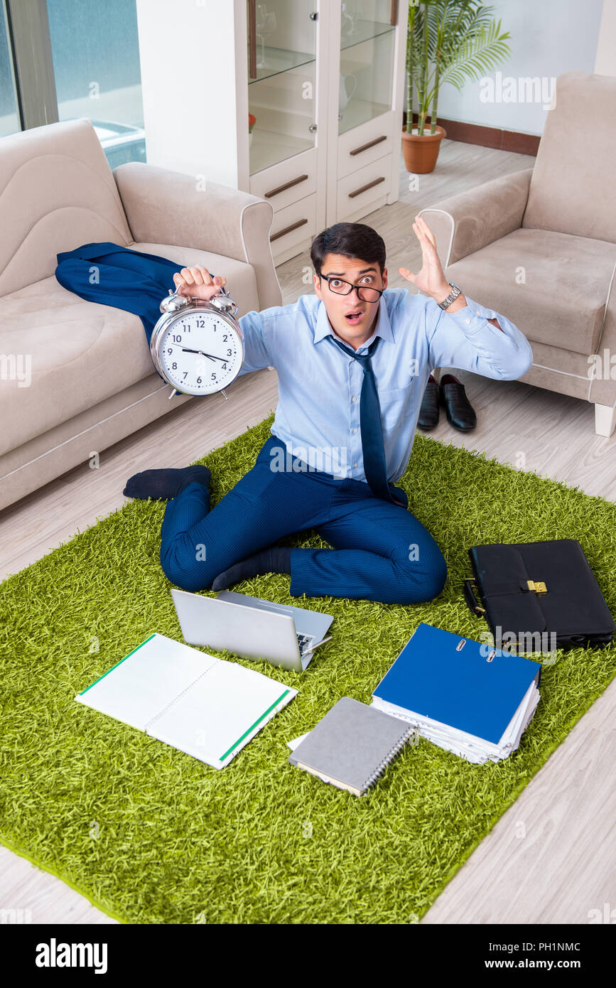 Businessman taking work home and working overtime Stock Photo - Alamy