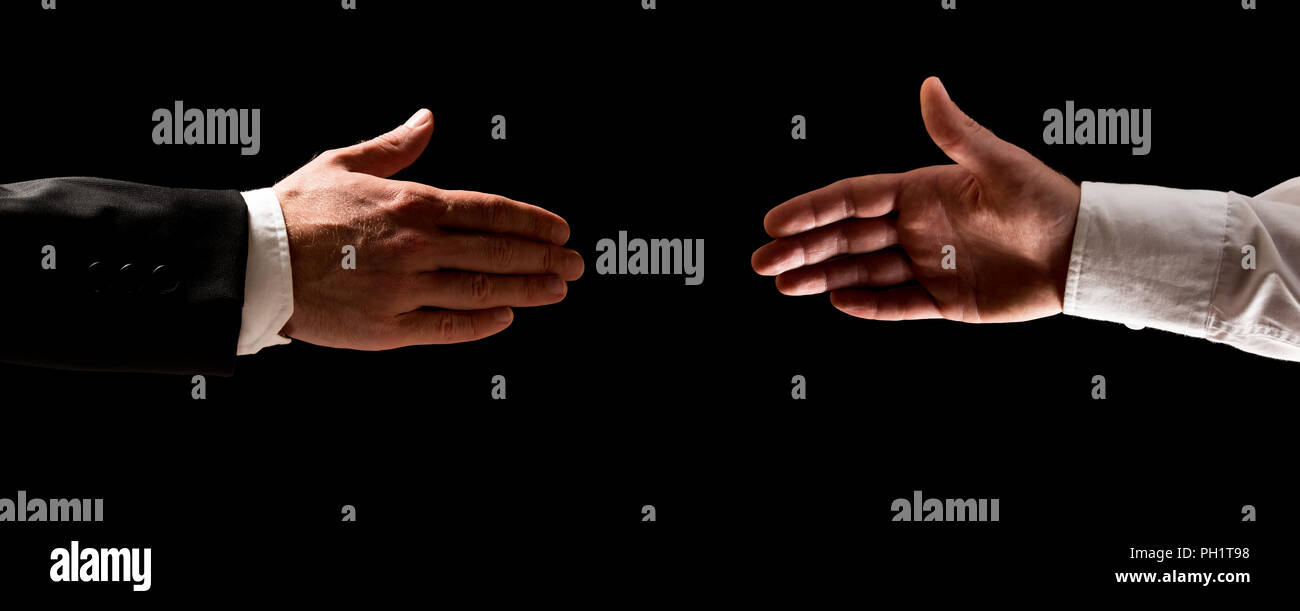 Two men reaching out to shake hands, one in a suit and the other in his ...