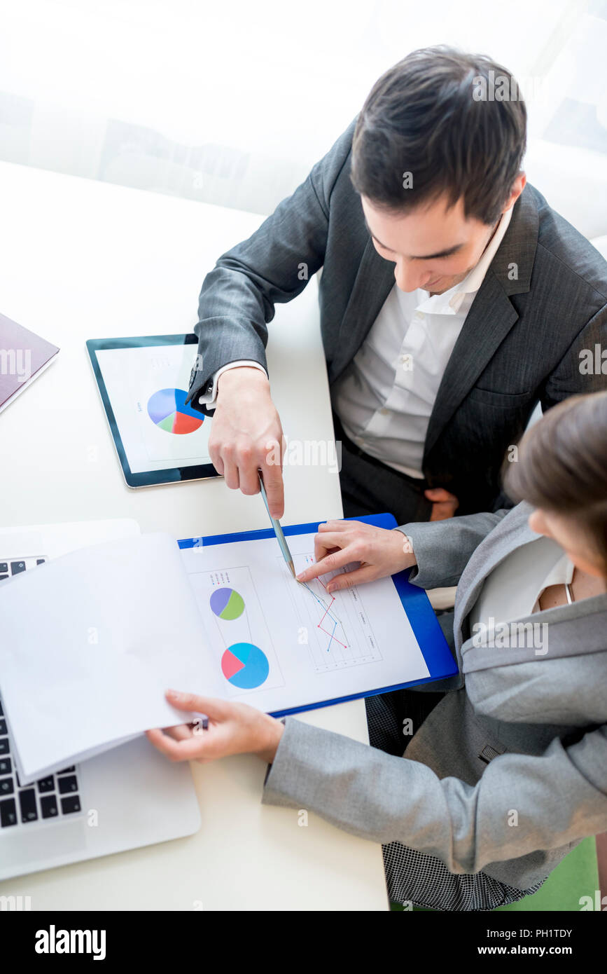Two business partners analysing a financial report discussing the ...