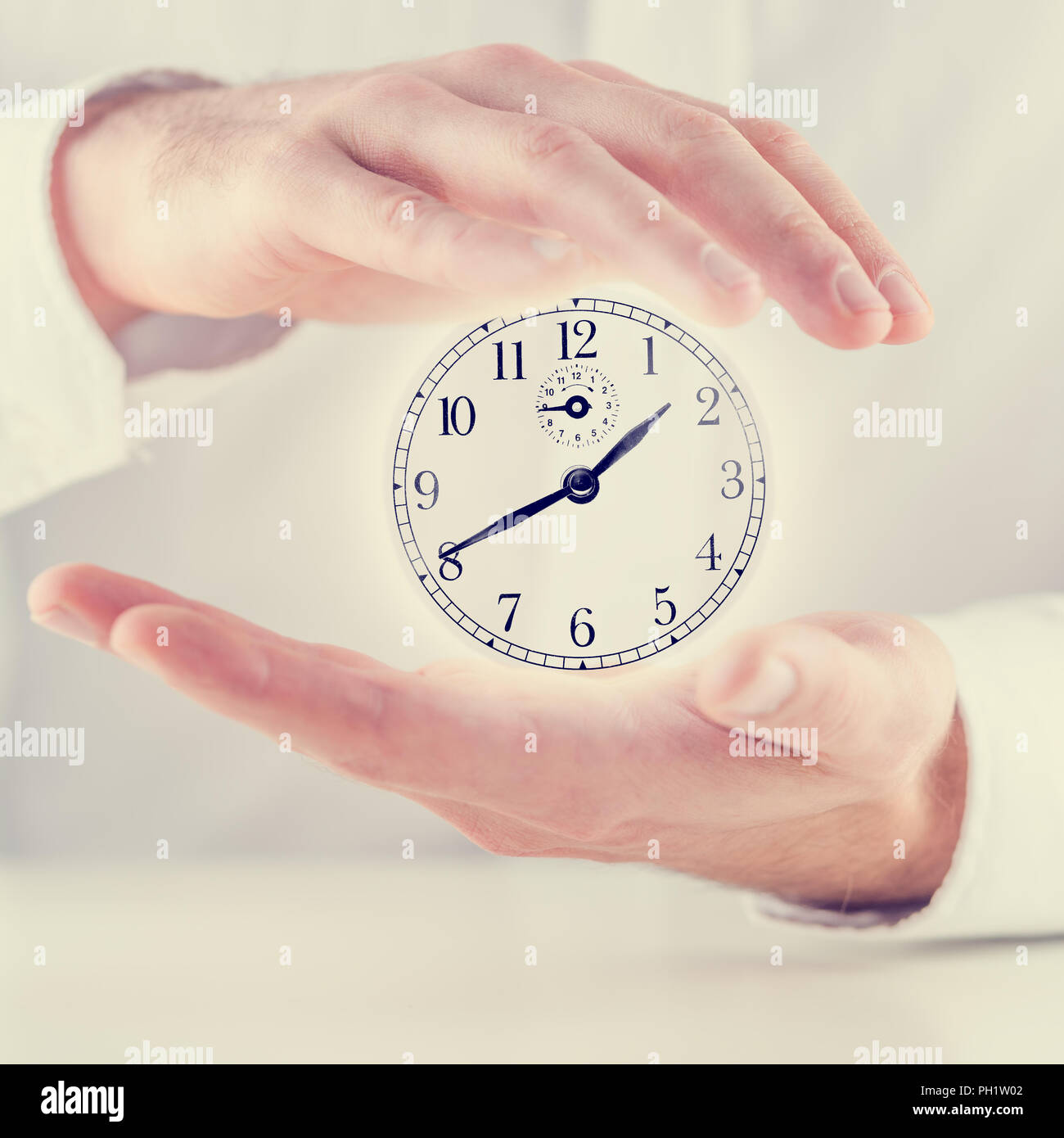 Retro image of male hands making a protective gesture around clock face ...