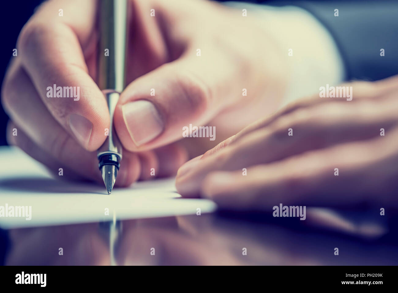 Retro effect faded and toned image of a man writing a note with a ...