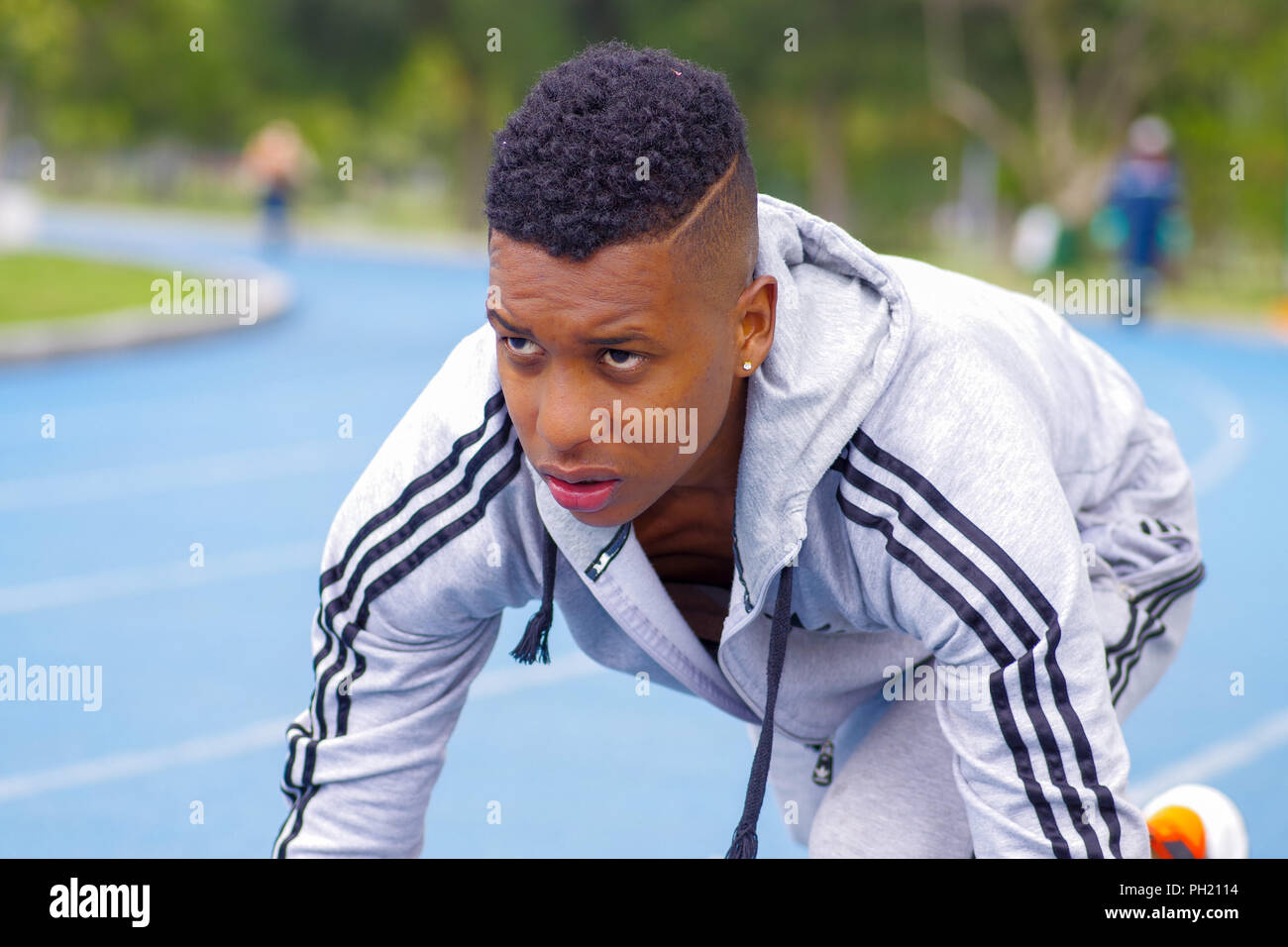 Portrait of black young determined man wearing a gray running sport ...