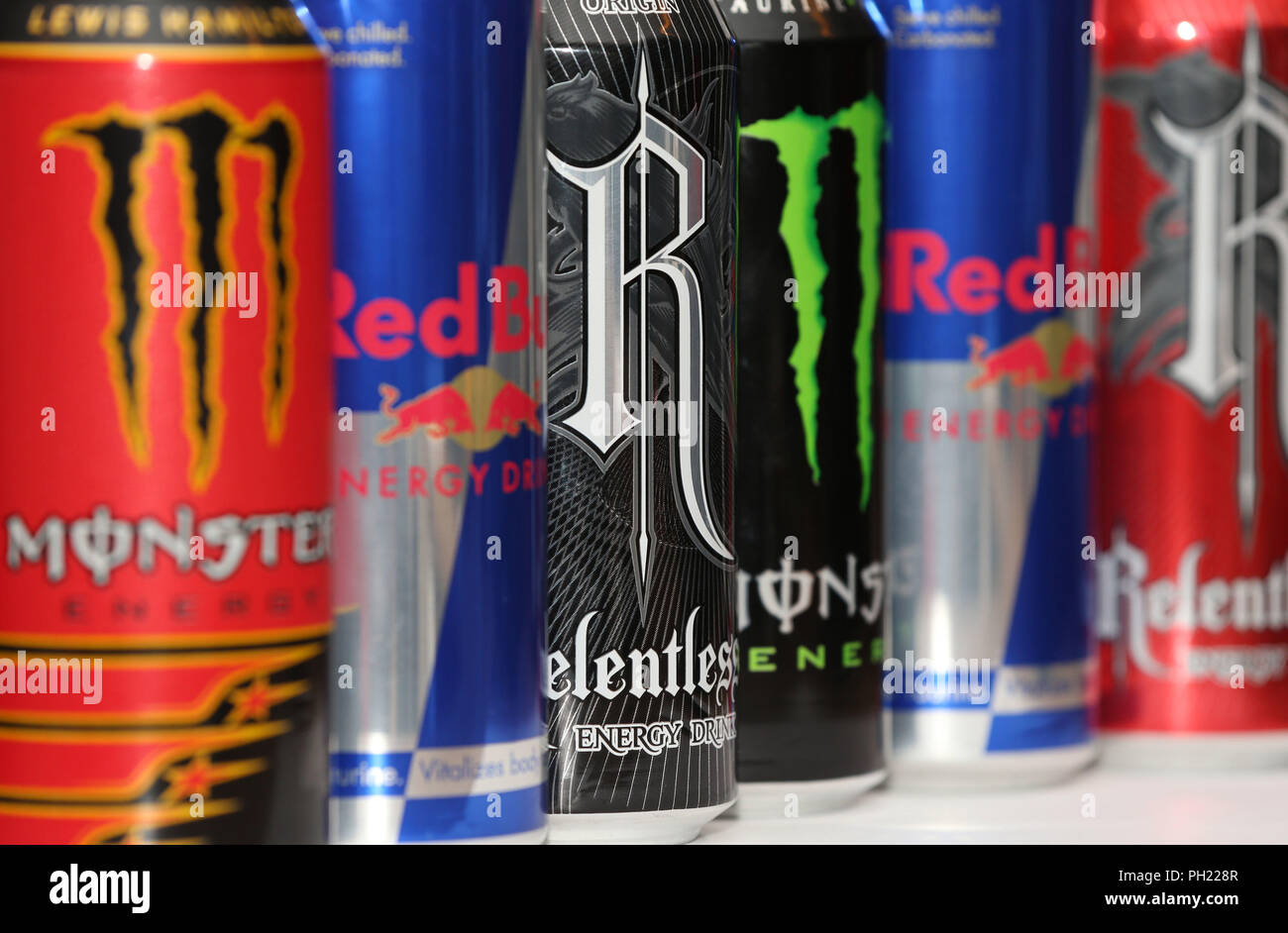 Cans of Red Bull, Monster and Relentless energy drinks. Children in ...