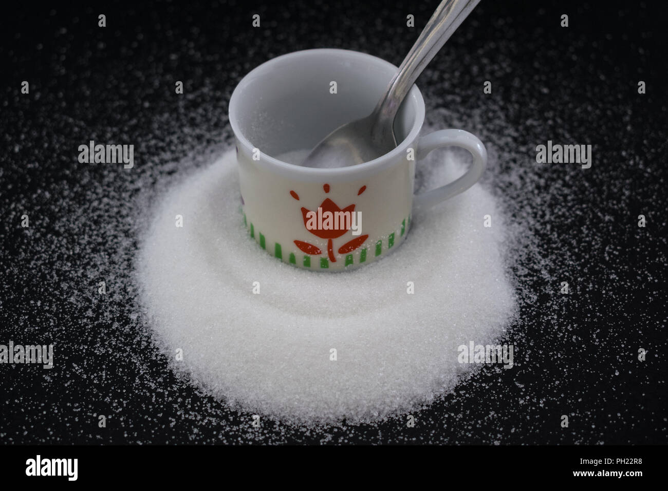 coffee cup surrounded by a lot of sugar in black background Stock Photo ...