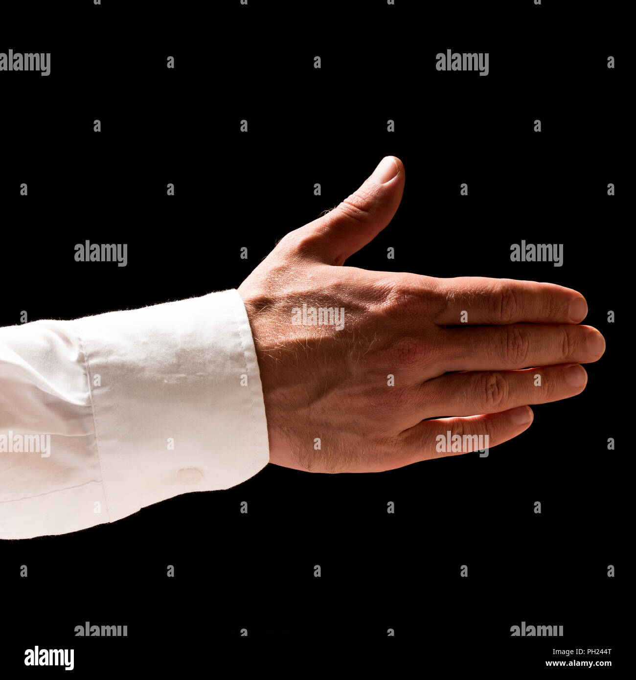 Man in shirt sleeves extending his hand in a handshake in greeting, to ...