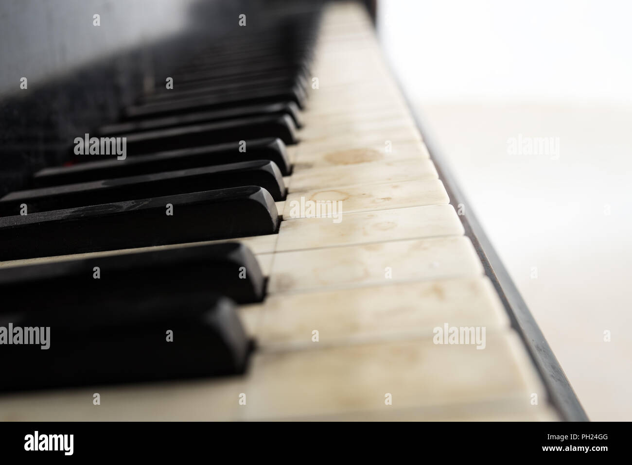 Low angle view of an old piano keyboard with stained ivory keys looking ...