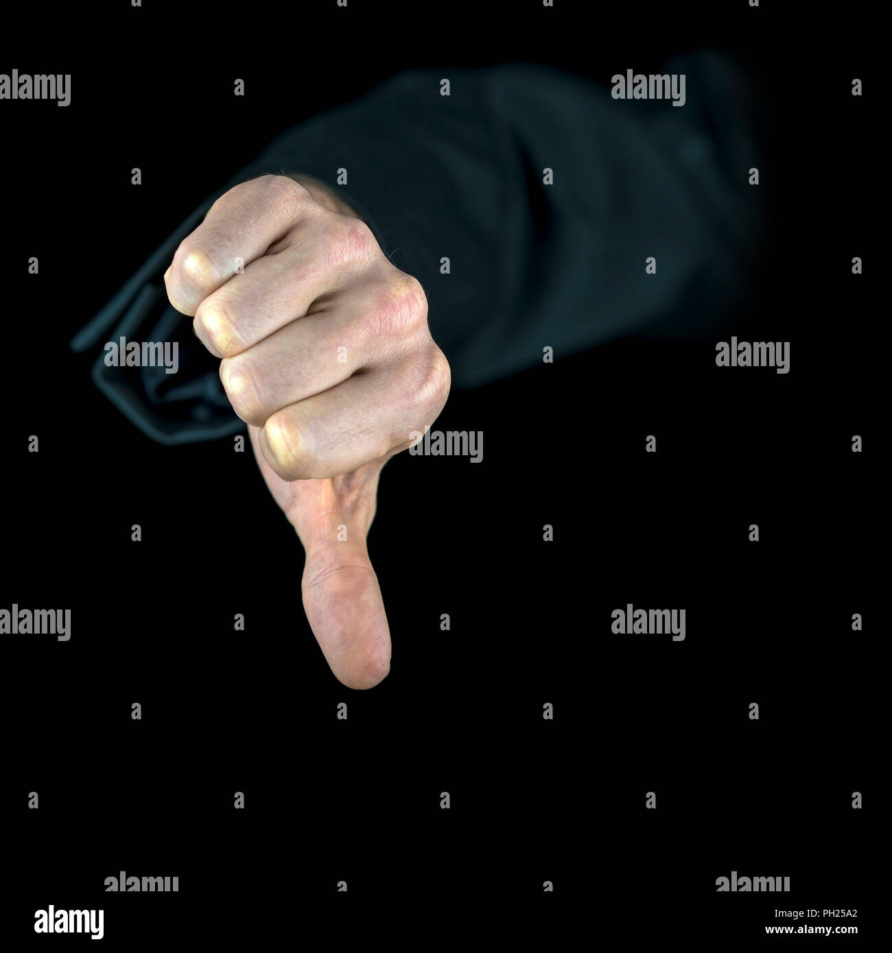 Close-up of a hand with black sleeve showing the thumb down, gesture of ...