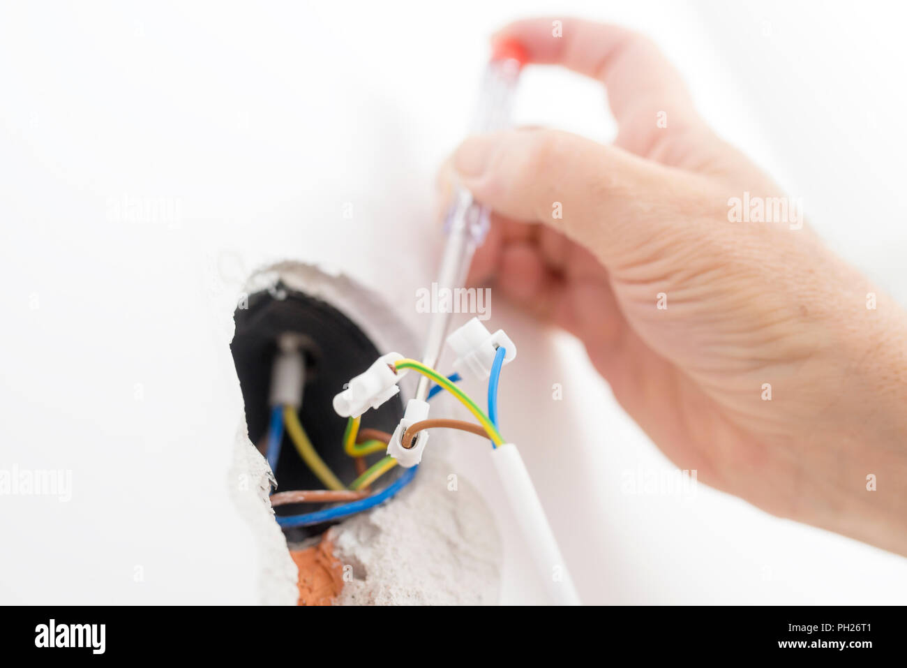 Closeup of electrician checking electrical current in a wire ...