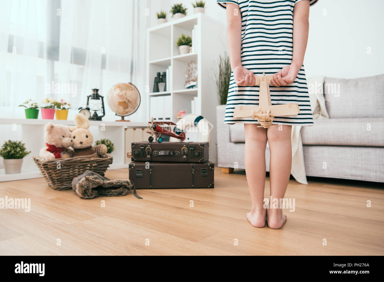 kid standing and putting her arms behind the back. Carefully holding ...