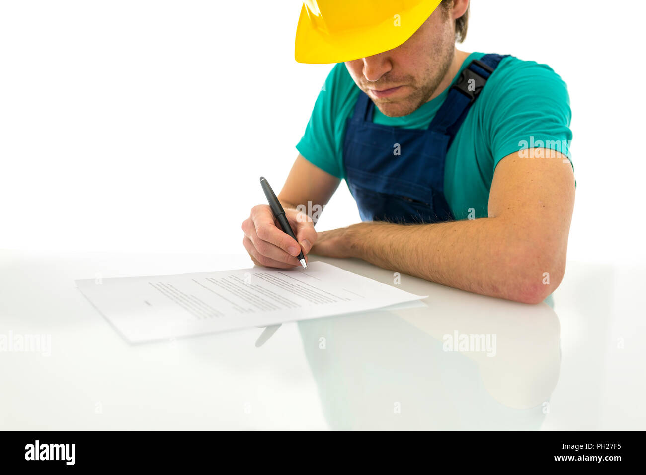 Young construction worker signing contract on white desk. Over white ...
