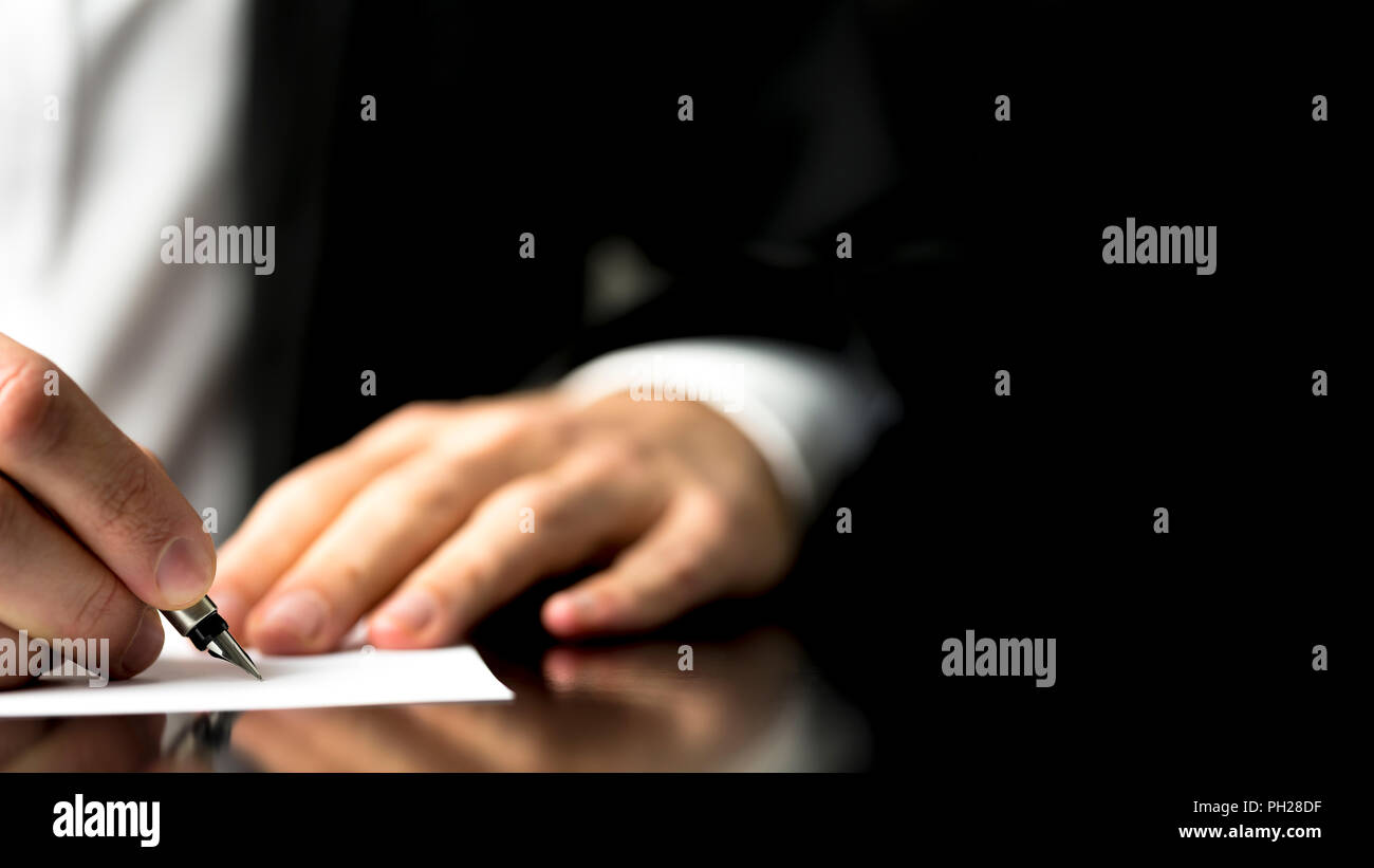 Businessman writing correspondence or signing a document using a ...
