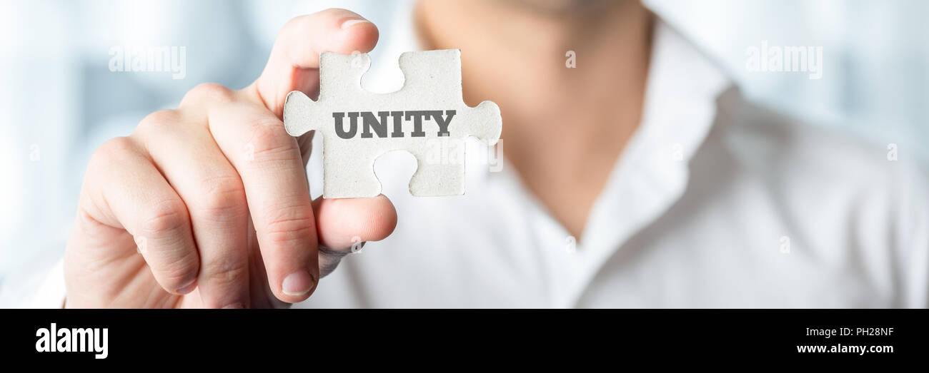 Businessman Showing a Conceptual White Jigsaw Puzzle Piece with Unity ...