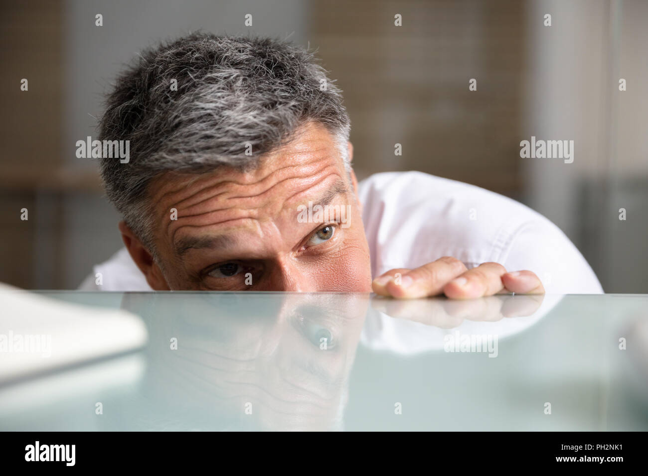 Person hiding under desk hi-res stock photography and images - Alamy