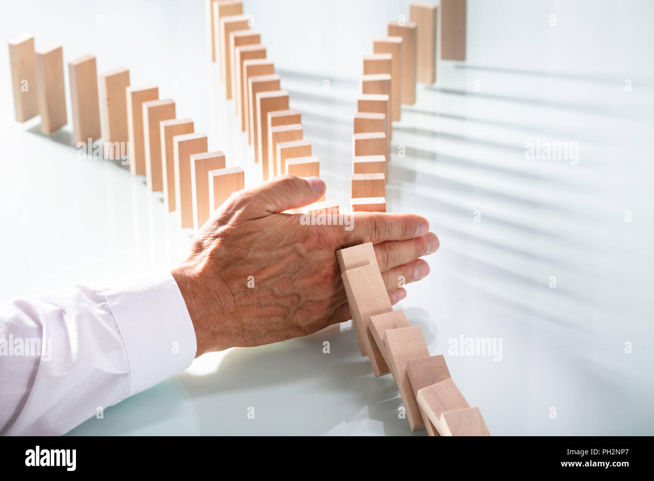 Close-up Of Businessman's Hand Stopping Wooden Blocks From Falling On ...